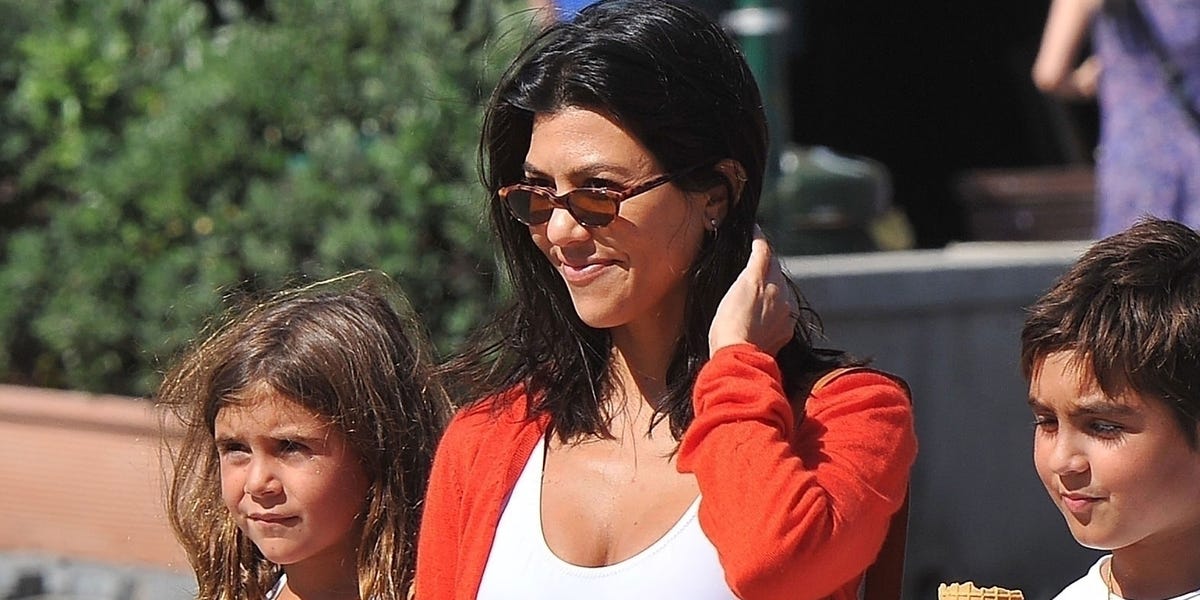 Kourtney Kardashian Orange Shorts And White Bodysuit Sideboob Outfit