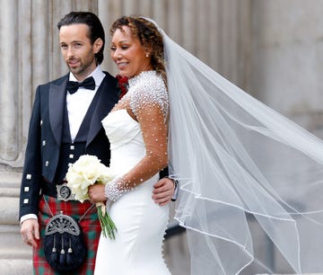 rory mcphee and mel b in wedding attire with a bouquet